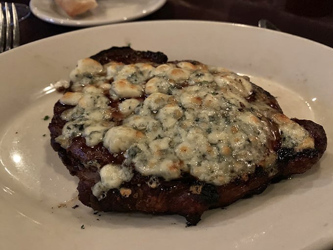 Blue cheese melts languidly over a perfectly seared ribeye, creating a flavor combination that might just make you believe in destiny.