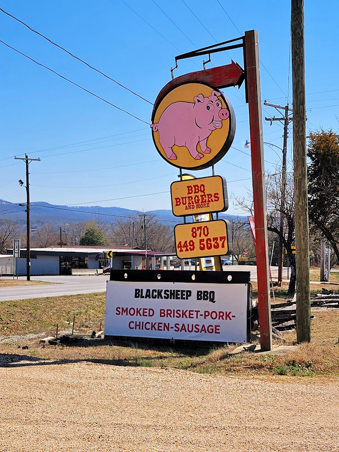 That pink pig sign against the Ozark Mountain backdrop isn't just directions&mdash;it's a beacon of hope for the hungry traveler.
