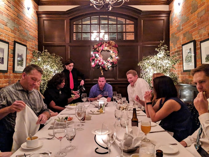 The private dining area offers a more intimate setting where brick walls and wooden accents create a warm backdrop for special occasions. 