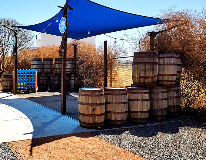 Wooden barrels and blue skies create the perfect outdoor hangout. That oversized Connect Four game promises friendly competition after a pint.