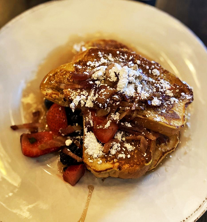 French toast's fancy cousin makes an appearance, dusted with powdered sugar like fresh snow on a delicious mountain of flavor.