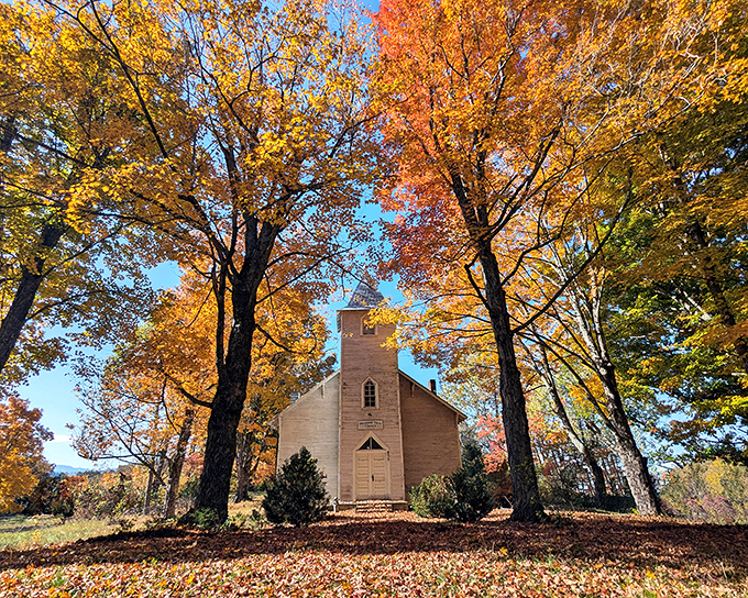 Fall foliage frames this country church in nature's most spectacular display. No filter needed when Mother Nature handles the art direction herself.