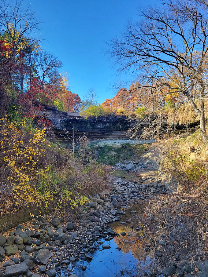 Fall foliage frames the creek bed in autumn's palette. Even when the water recedes, the view remains a masterpiece.