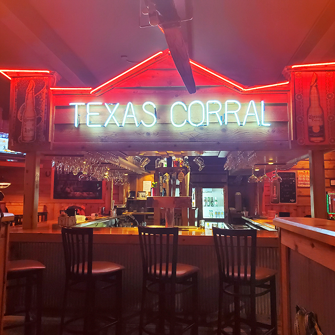 The bar's neon sign burns bright like a lighthouse guiding hungry travelers to safe harbor, where beer taps stand ready for service.