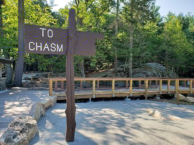 Follow this rustic wooden signpost toward a dramatic geological wonder, passing a steady boardwalk and sun-drenched paths along your journey.