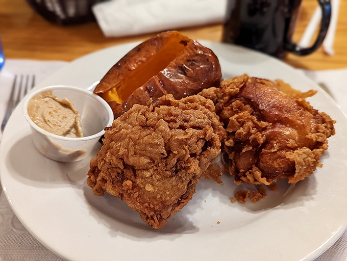 Broasted chicken with skin so crispy it practically shatters, paired with a sweet potato that's basically wearing dessert clothes.