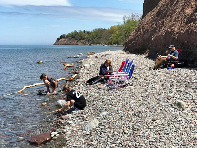 Families enjoying the stone beach beneath towering bluffs &ndash; no sand in your sandwiches, just memories in the making.