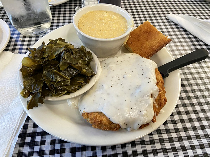 Country fried steak hidden under pepper gravy, with collard greens that have clearly been cooking since breakfast yesterday.