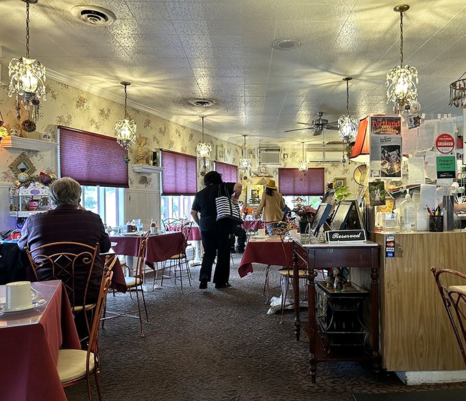 Chandeliers and purple window treatments create an unexpected elegance in this diner, where breakfast is served with a side of charm. 