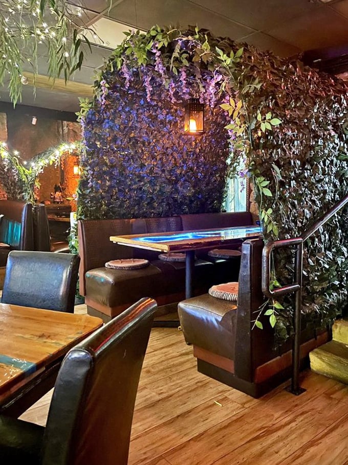 A booth that feels like a secret garden nook, where private conversations happen under a canopy of purple-hued foliage.