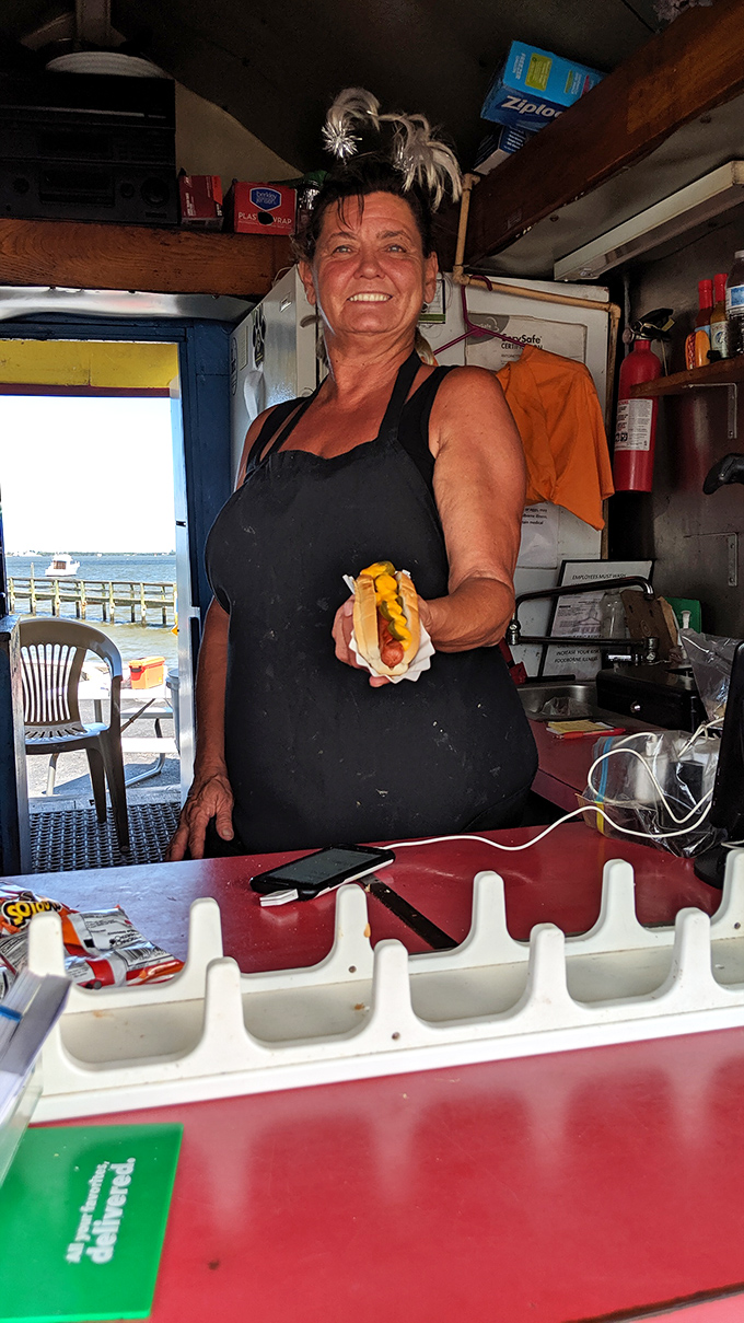 The wizard behind the curtain, crafting hot dog magic in a tiny kitchen with a smile that says, "Just wait till you taste this."