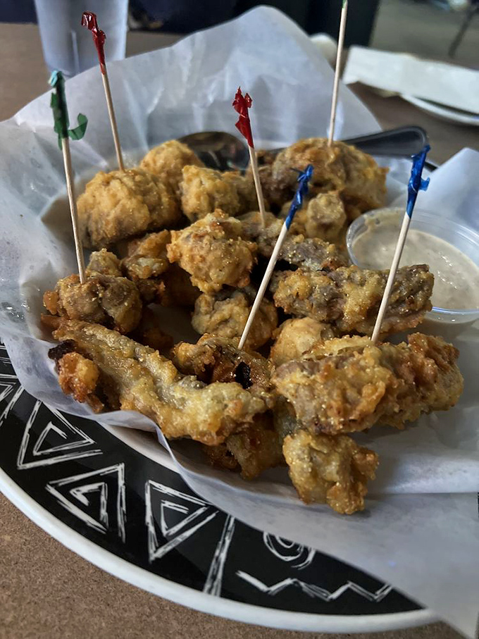 Fried mushrooms with festive toothpicks saying, "We're dressed up, but we're still fun." The cocktail party guest of appetizers.