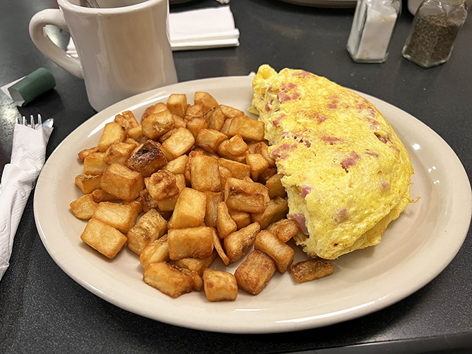 An omelet that's achieved that perfect balance of fluffiness and substance, flanked by home fries that could convert a hash brown loyalist.