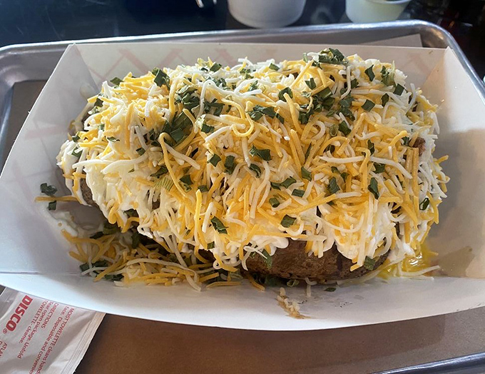 A loaded baked potato that's practically wearing a cheese sweater. This spud didn't just get dressed &ndash; it got completely decked out.