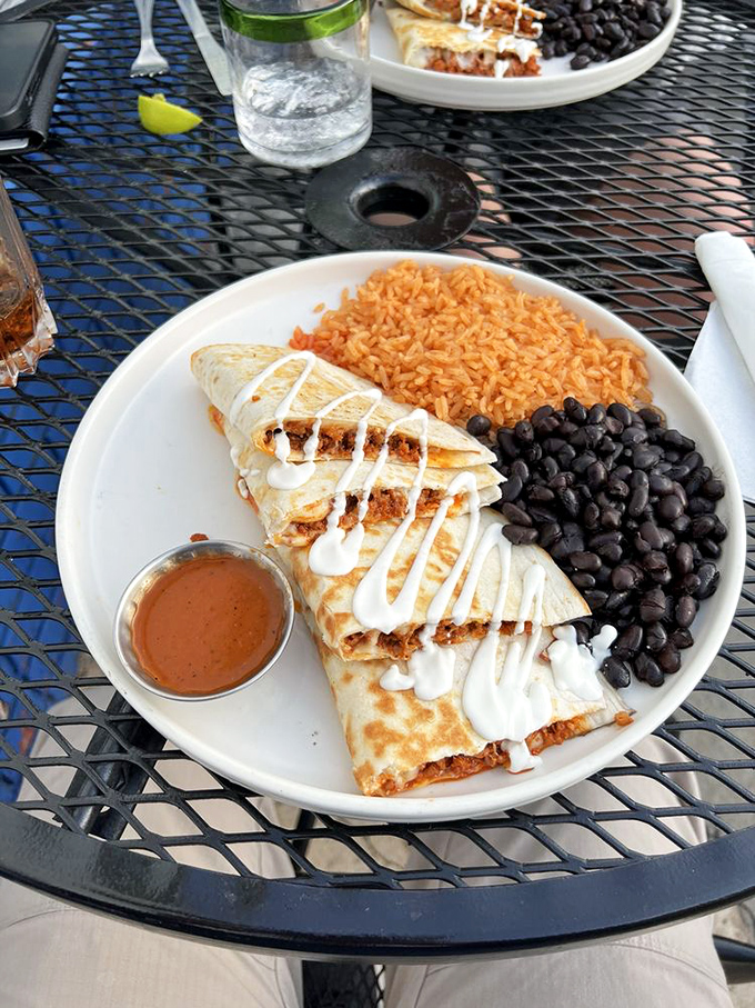 Quesadillas that achieve the golden ratio of crisp exterior to molten interior. That sauce cup holds liquid treasures worth fighting over.