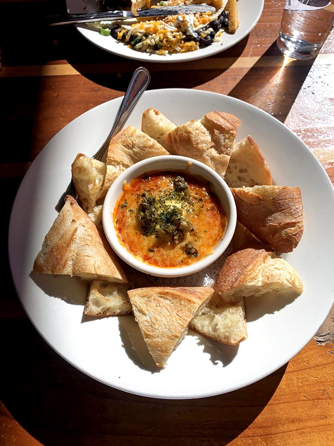 This isn't just melted cheese&mdash;it's a warm embrace in dip form. Surrounded by crusty bread triangles waiting for their moment of glory. 
