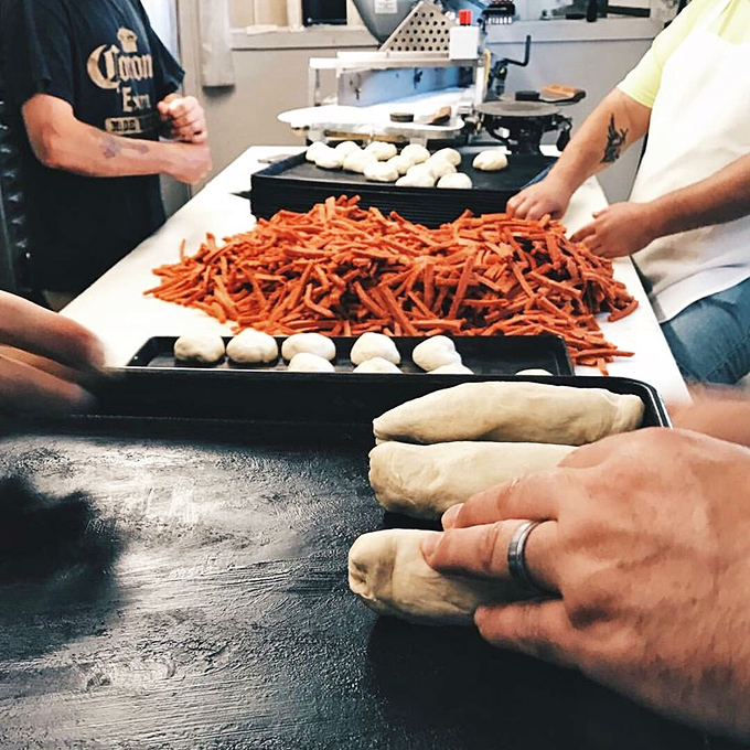 The sacred assembly line where magic happens. Skilled hands transform simple ingredients into cultural icons, a choreographed dance of dough and pepperoni.