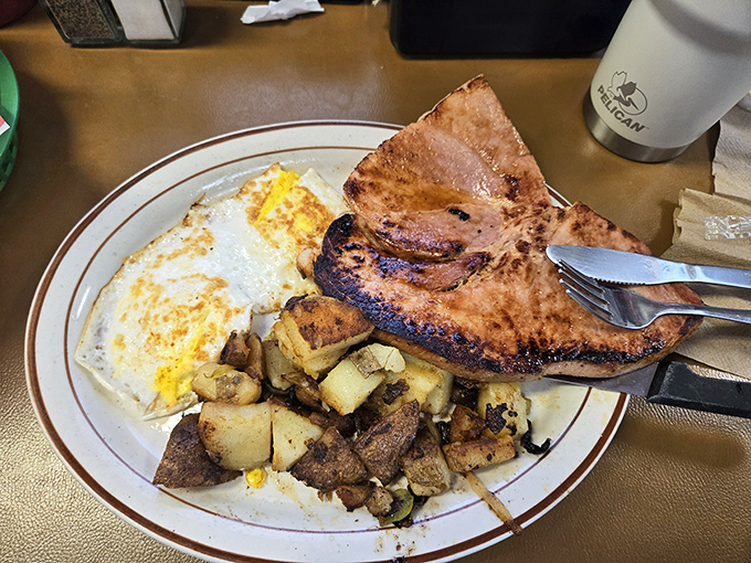 Breakfast of champions: perfectly cooked eggs, ham steak, and home fries with toast standing by for yolk-sopping duty. Morning fuel that keeps Oklahomans going.
