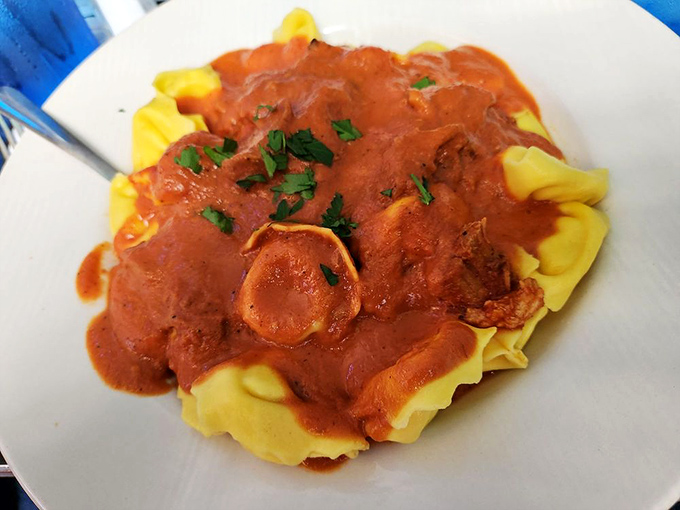 Yellow tortellini wearing tomato sauce like couture&mdash;pasta pillows that prove sometimes the simplest dishes require the most skillful hands.