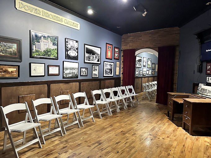 The Powers Brothers Gallery awaits its audience. These wooden chairs have heard more fascinating stories than a bartender on Saturday night.