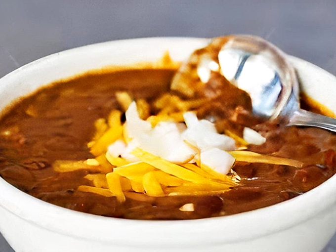 Chili that demands respect&mdash;thick, hearty, and topped with the holy trinity of shredded cheese, diced onions, and just enough spice to wake up your taste buds.