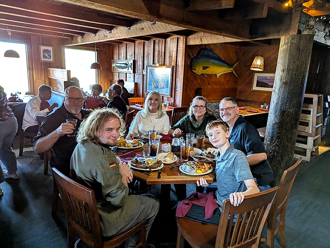 Happy diners surrounded by wooden beams and nautical decor &ndash; the universal expression of "we ordered exactly the right thing" on every face.