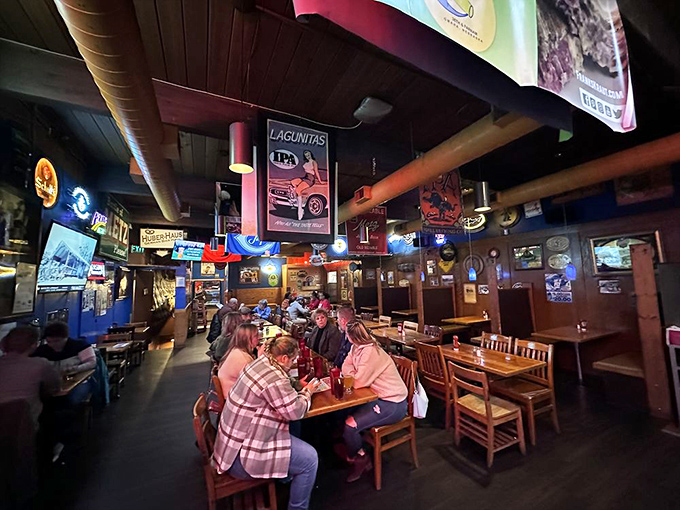 Diners lean in over wooden tables, the neon glow creating that perfect ambiance where food and conversation flow equally well.