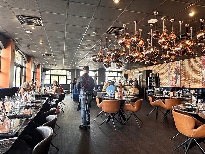 Copper pendant lights cast a warm glow over diners enjoying that magical moment when conversation and cuisine create perfect harmony.