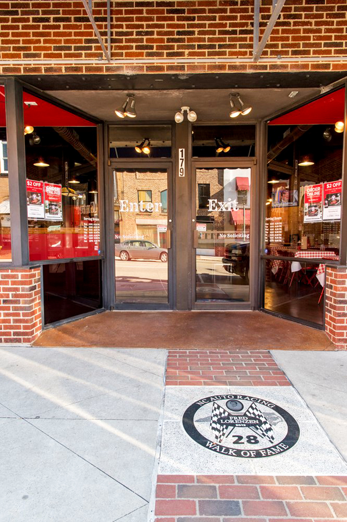 This entrance isn't just a doorway&mdash;it's a portal to a parallel universe where smoke, time, and meat create magic. Note the racing tribute&mdash;speed isn't just for cars.