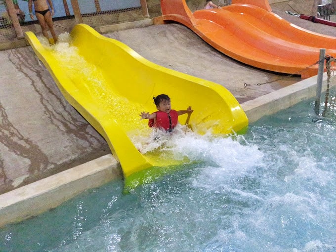 That yellow slide delivers exactly what childhood summers should: a perfect combination of brief terror followed by triumphant splashdown.