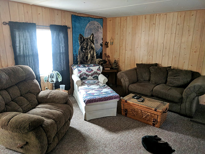 Rustic comfort meets cabin chic in this wood-paneled living space, where the wolf artwork watches over your vacation napping with silent approval.