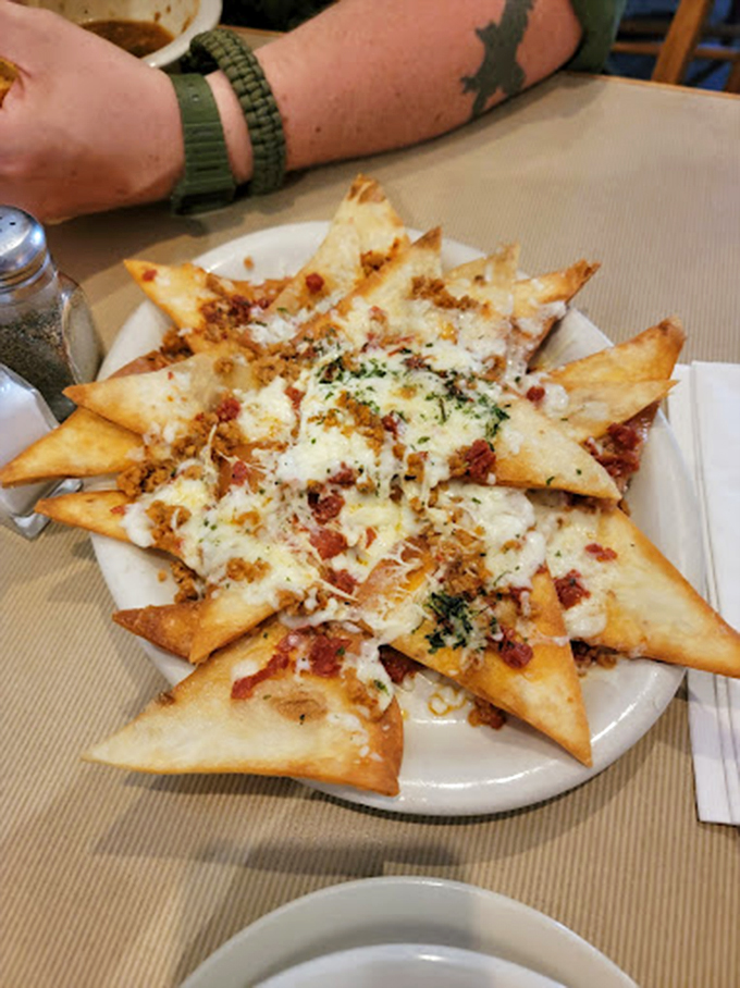 These aren't just nachos—they're a geometric marvel of triangular perfection, topped with a snowfall of cheese and savory treasures.