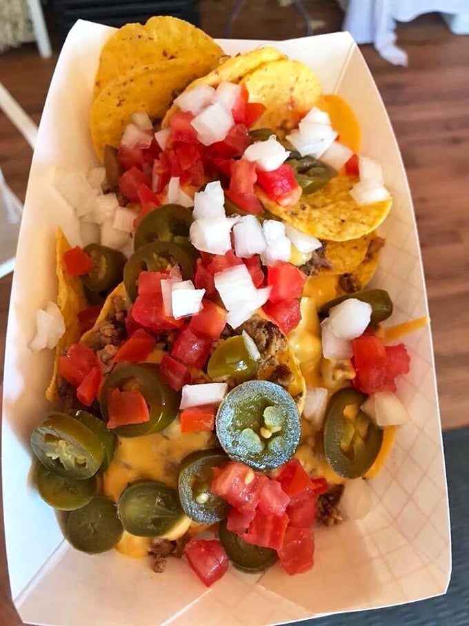 These nachos aren't just topped &ndash; they're celebrating under a confetti of fresh jalape&ntilde;os, tomatoes, and onions that make every bite a fiesta.