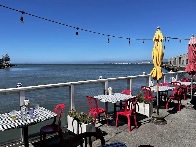 Red chairs, checkered tablecloths, and endless bay views&mdash;a reminder that sometimes the best restaurant d&eacute;cor is simply Mother Nature showing off.