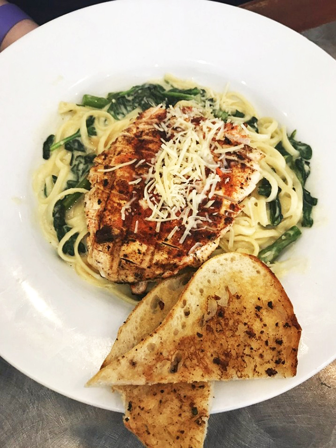 Proof that lunch deserves love too: perfectly grilled chicken atop pasta with spinach and garlic bread that could convert breakfast purists.