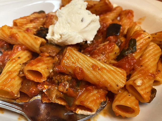 This isn't just pasta – it's a saucy Italian hug topped with a cloud of ricotta that makes you want to book a flight to Naples.