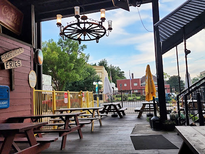 Picnic tables and wagon wheel chandeliers create an outdoor space that feels like the best backyard party you've ever crashed.