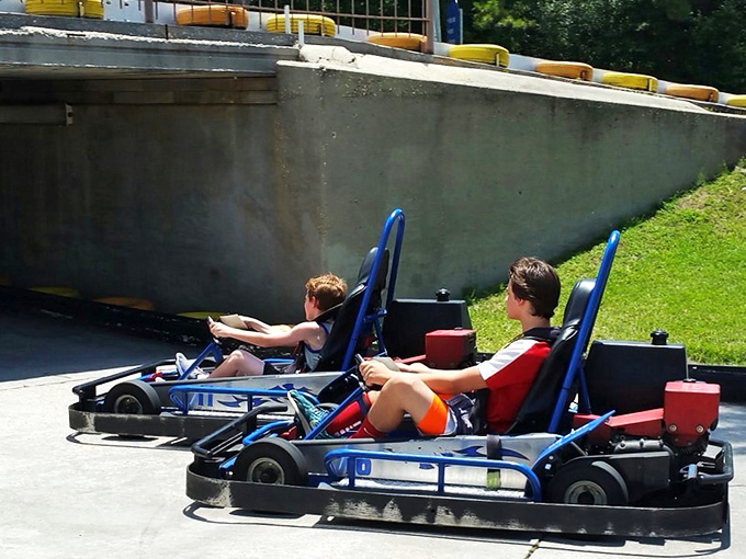 Two young racers demonstrating the universal truth that sibling rivalry finds its purest expression behind the wheel of competing go-karts. The track: family therapy disguised as fun.