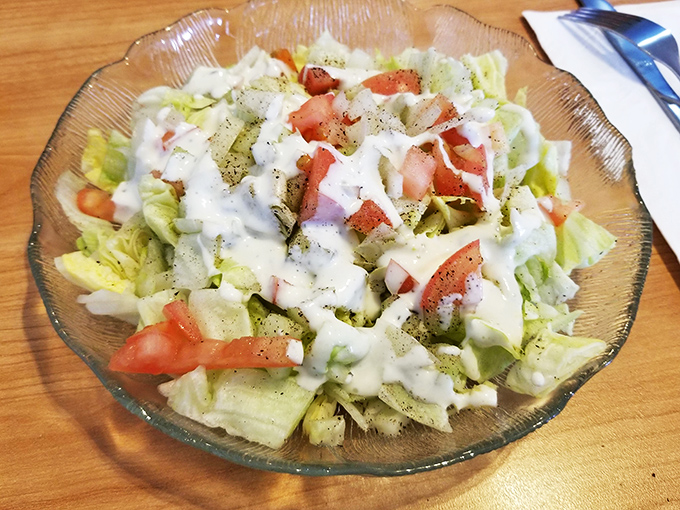 A simple garden salad that doesn't pretend to be anything fancy &ndash; just fresh, crisp vegetables with house dressing in a glass bowl that's seen thousands of meals.