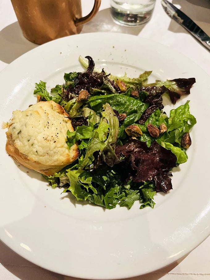 A garden-fresh salad that doesn't apologize for being healthy, accompanied by what appears to be the world's most perfect cheese biscuit.
