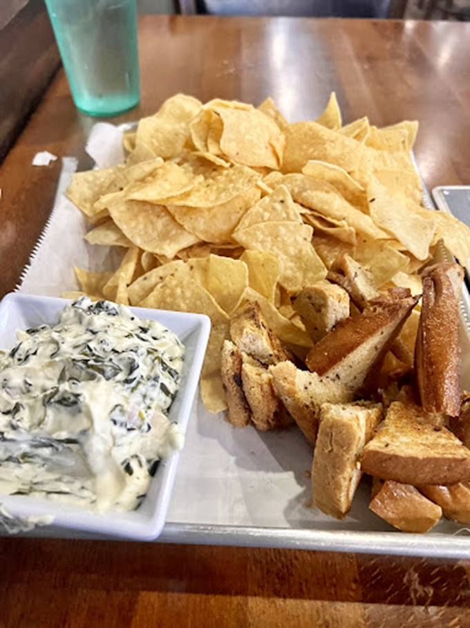 The spinach artichoke dip arrives with an entourage of chips and bread. A creamy, cheesy diplomatic mission between vegetables and indulgence.