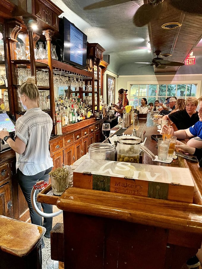 The bar at 82 Queen balances historic charm with modern expertise. Those wooden cabinets behind the bartender have probably witnessed more secrets than a confessional.