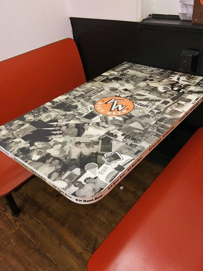 These tables preserve local history under glass&mdash;each black and white face a customer who discovered the magic of K N years ago.