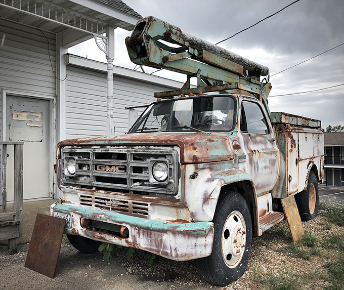 Out back, a rust-kissed utility truck enjoys retirement, having earned its rest after decades of service on the heartland highways of Missouri.