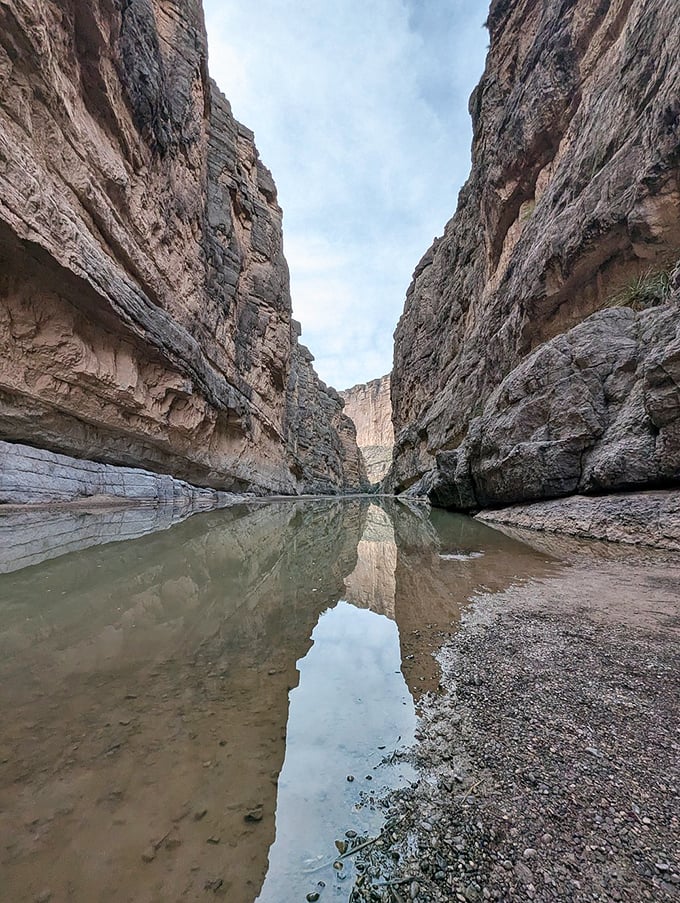 The calm waters reflect canyon walls with mirror-like precision, doubling the visual impact without charging extra.