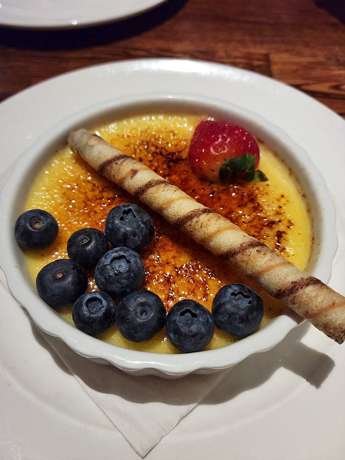 This cr&egrave;me br&ucirc;l&eacute;e isn't just dessert&mdash;it's performance art with a crackling sugar top, fresh berries, and a pirouette cookie standing at attention.