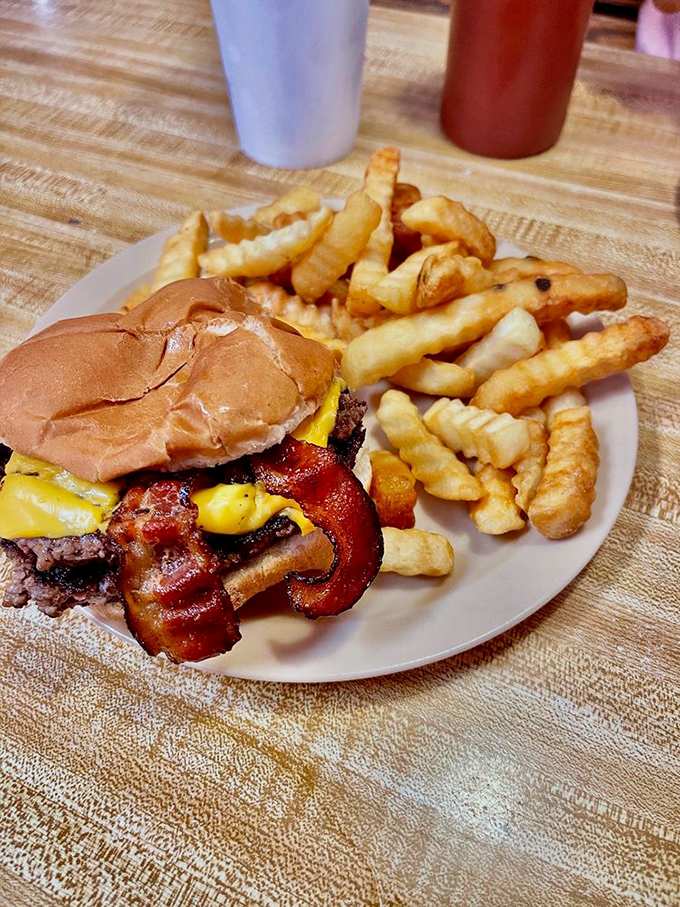 Behold the double bacon cheeseburger with a side of golden fries. This plate represents everything right with American cuisine&mdash;simple, honest, and utterly delicious.