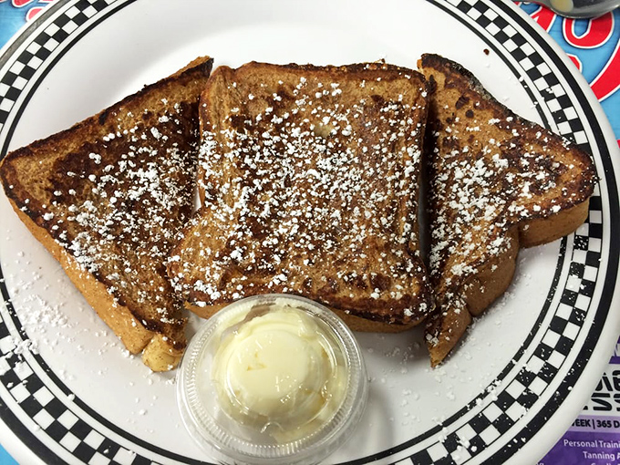 French toast that wears its powdered sugar like a winter coat. The butter cup on the side isn't a suggestion&mdash;it's an essential part of the experience.