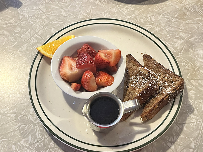 French toast done right&mdash;golden, crispy edges giving way to custardy centers. The fresh strawberries are there to help you pretend this is health food.