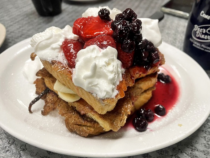 French toast stacked like a skyscraper of sweetness, crowned with berries and cream&mdash;breakfast masquerading as dessert, and we're not complaining.